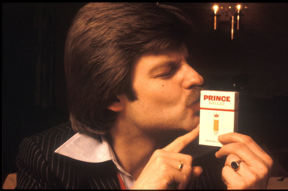 Reklamefoto av en mann som viser frem en pakke sigaretter av typen ...