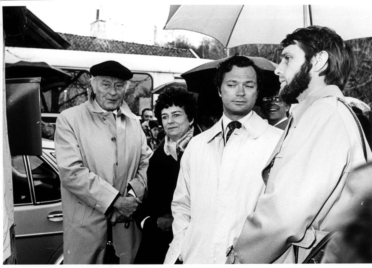 Kung Carl XVI Gustaf stående i mitten under ett paraply på besök i ...