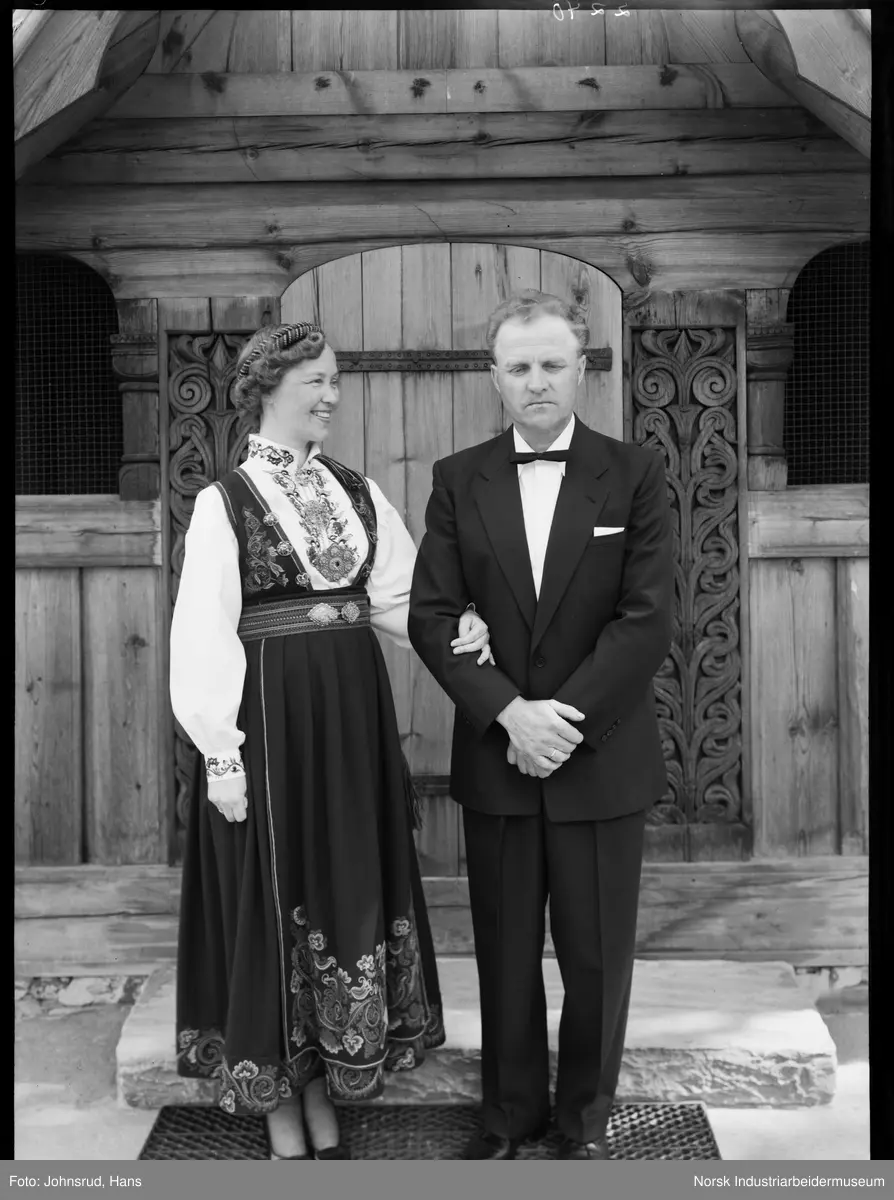 Brud i bunad og brudgom stående foran Heddal Stavkirke. - Norsk ...