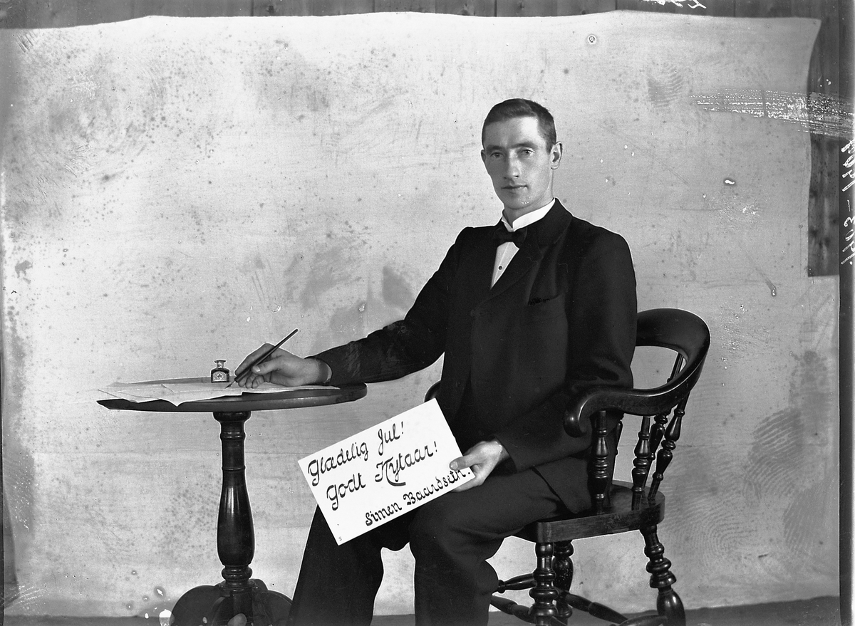 Simen Baardseth, selvportrett der han holder et jule og nyttårskort ...