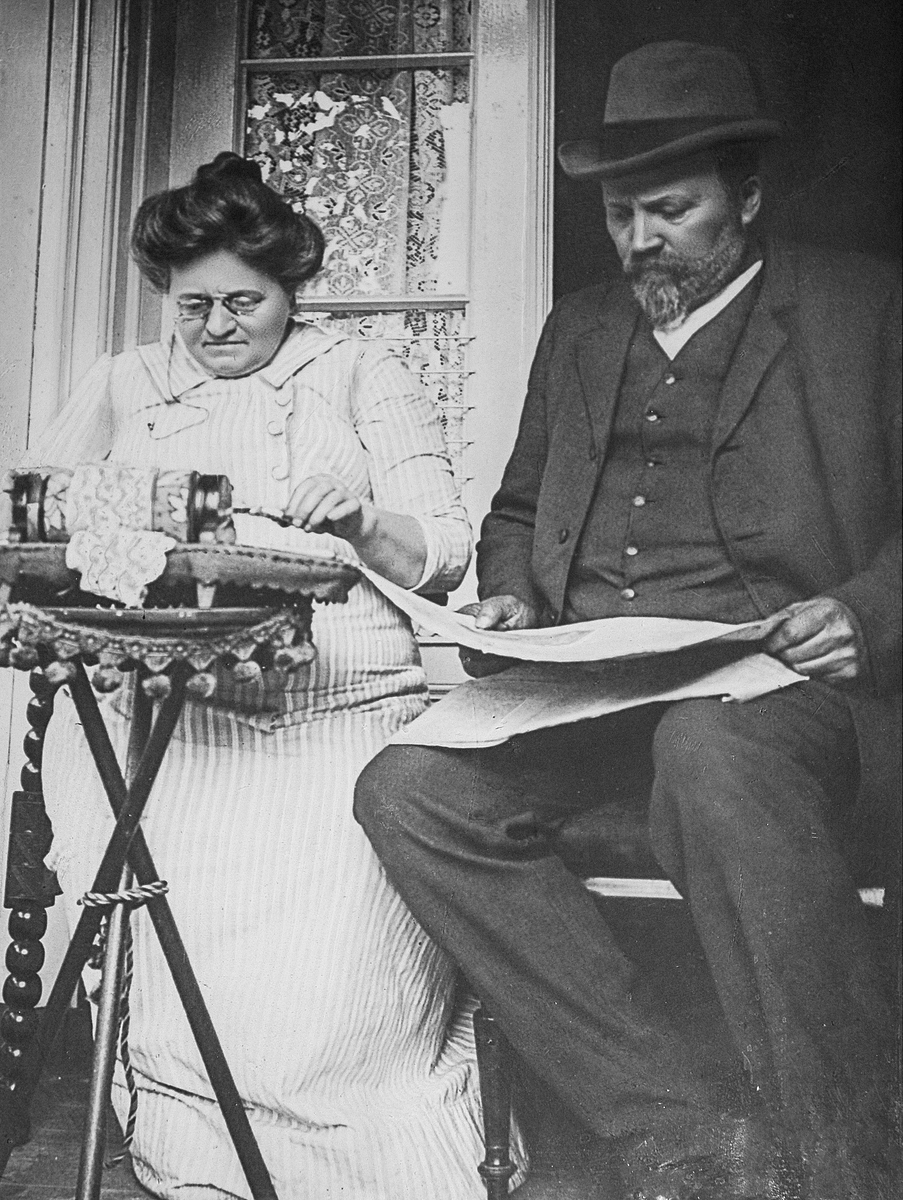 Hanna (med kniplingbrett) og Monthei Haug på verdandaen på Haug i 1912 ...