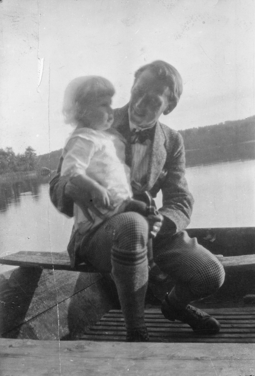 John Bauer med sonen Bengt "Putte" Bauer i knät sitter i en eka på sjön ...