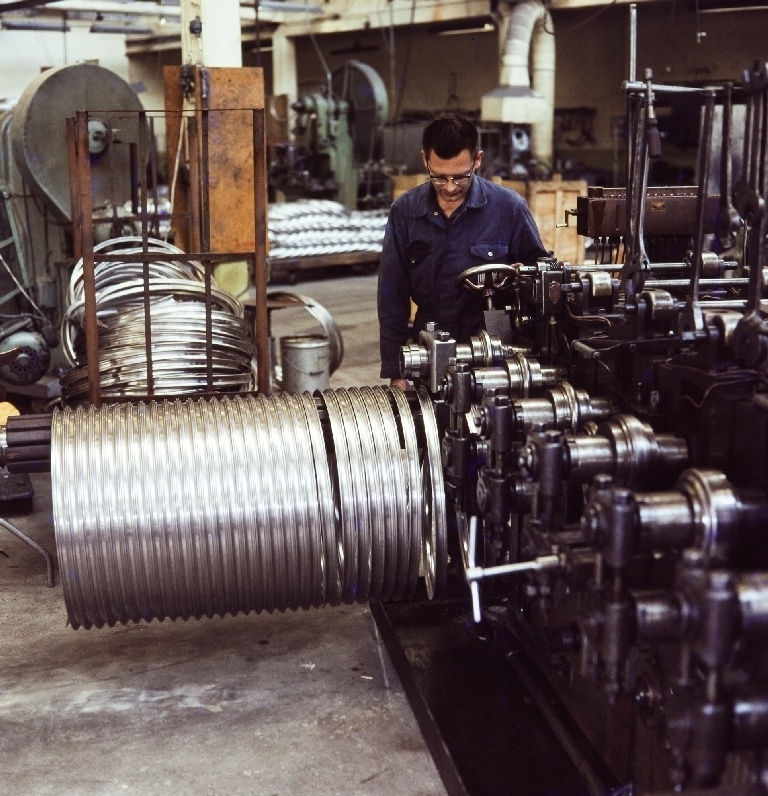 Arbeider ved maskin for valsing av felger i felgavdelingen til ...