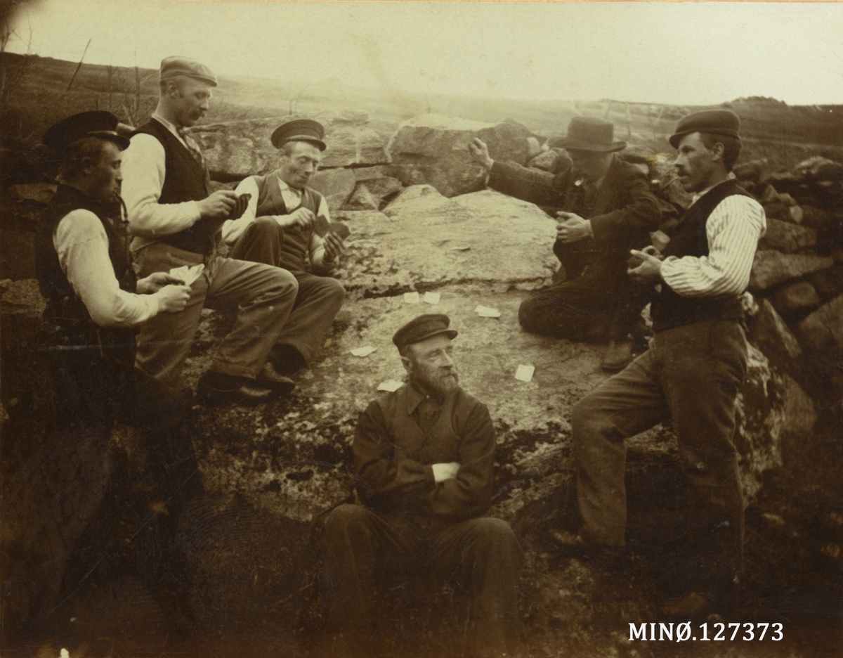 Menn på tur spiller kort på en diger stein - Anno Musea i Nord ...