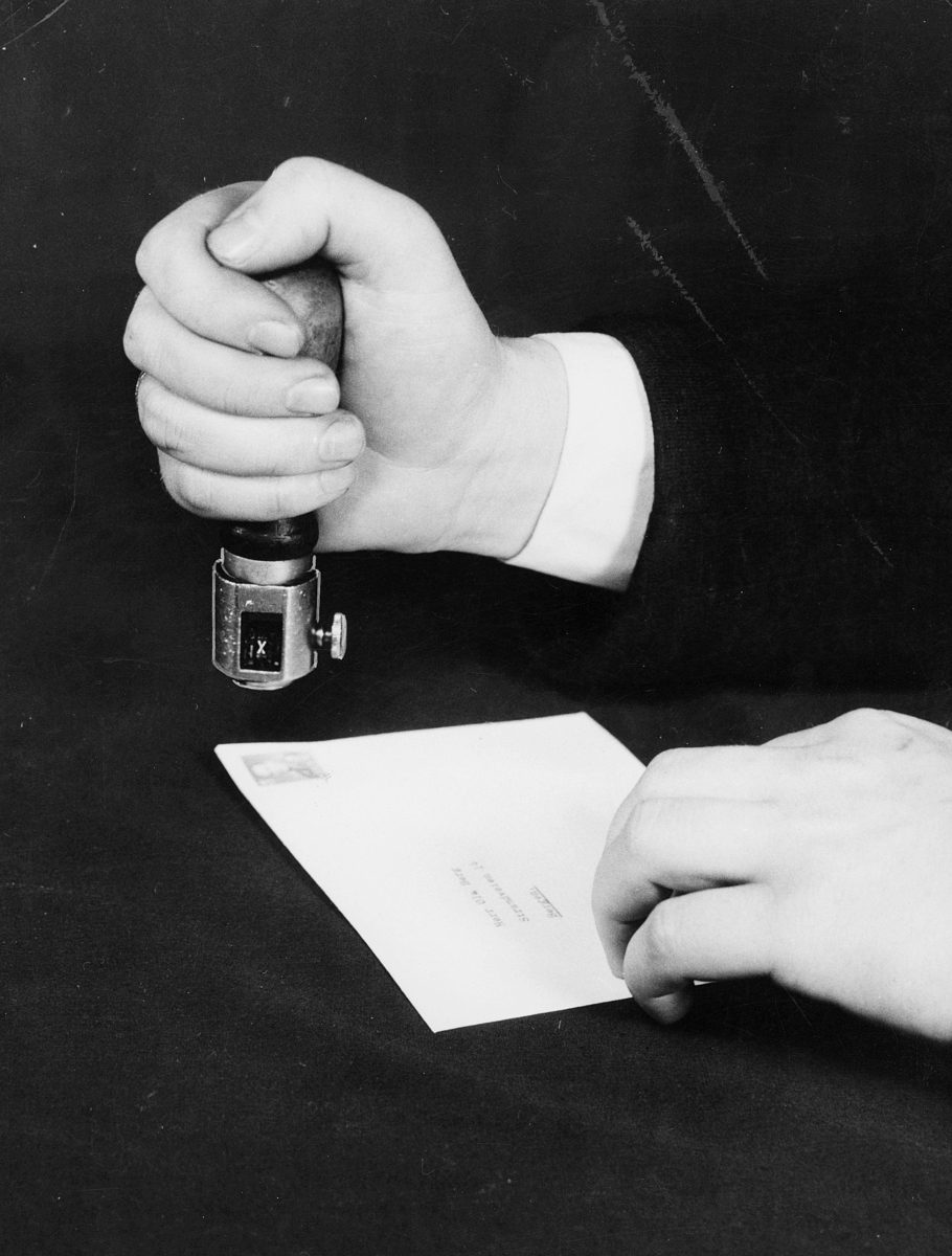 postbehandling, stempling, stempel, en person håndstempler et brev ...