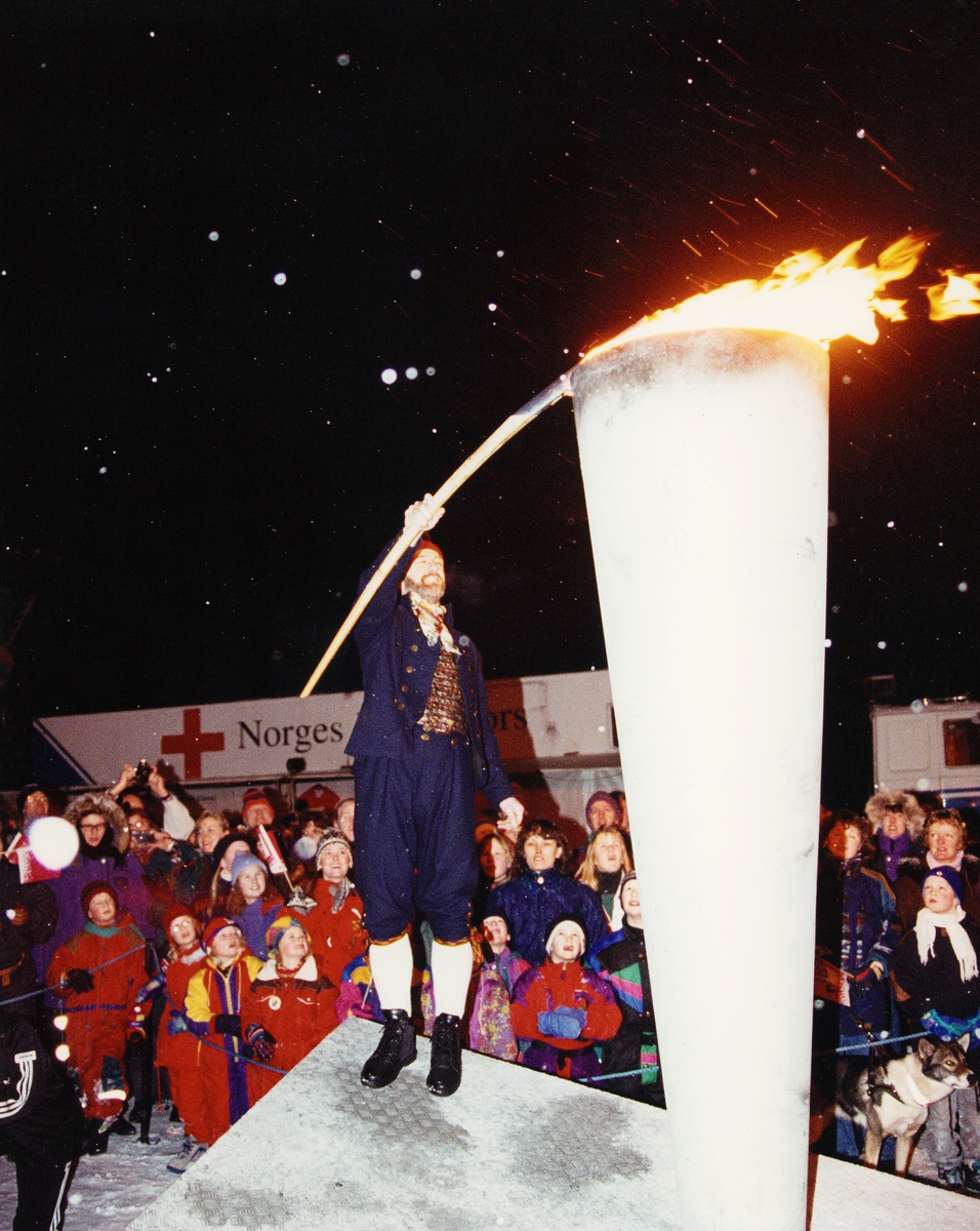 OL 1994, fakkelstafetten, Røros, stor fakkel på bakken, mann i blå ...