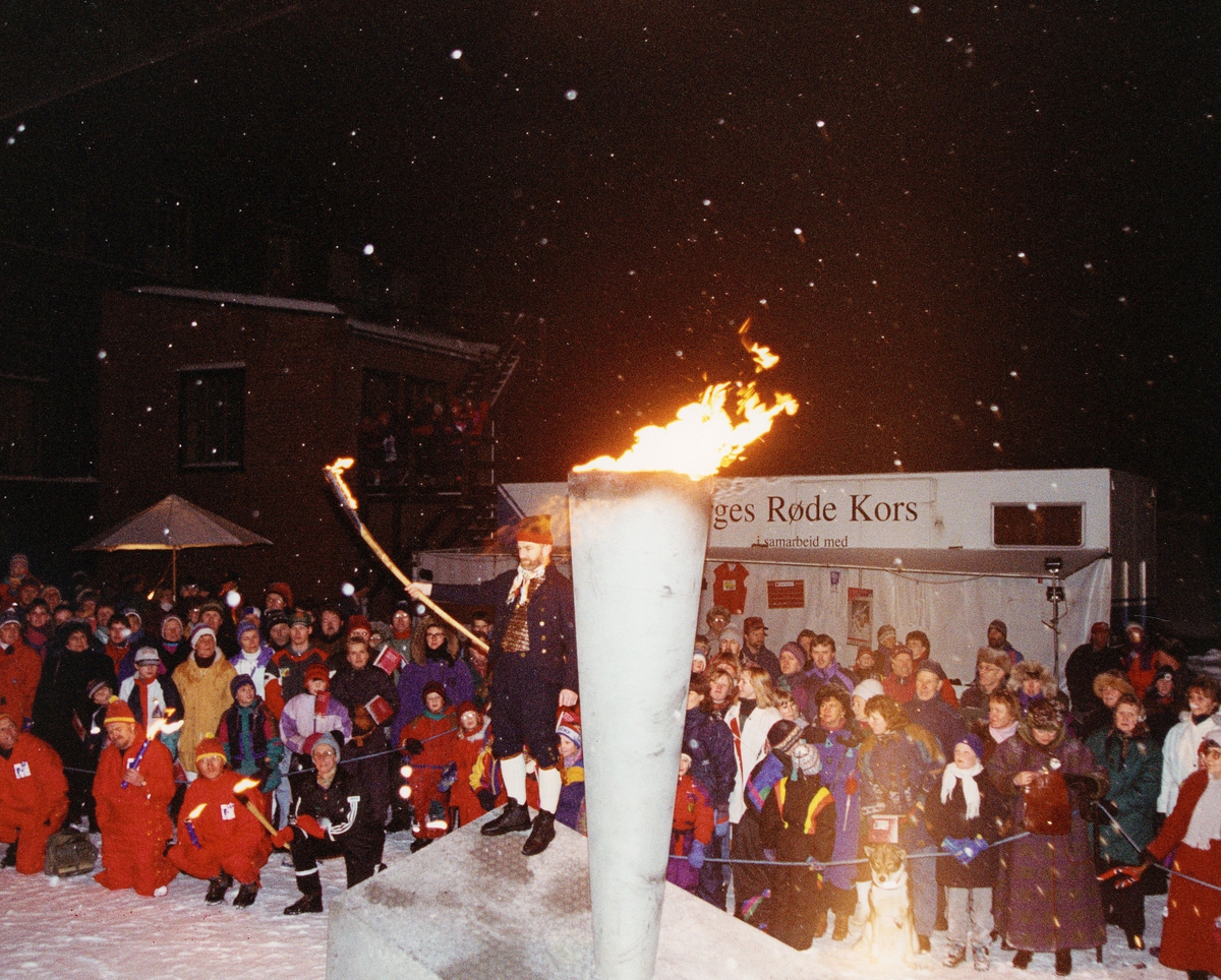 OL 1994, fakkelstafetten, Røros, mann i blå bunad holder fakkelen, stor ...